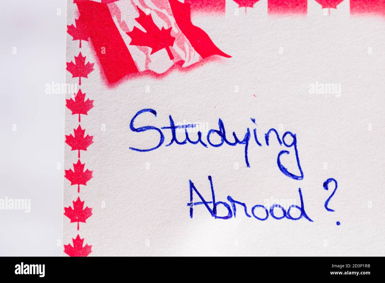 Studying abroad handwriting on paper with Canada flag. Writing text on ...