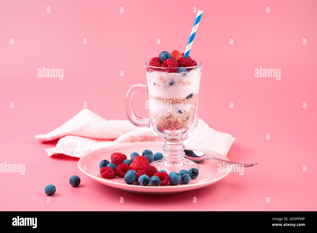 Berries and curd dessert with a glass on a pink background. Side view ...
