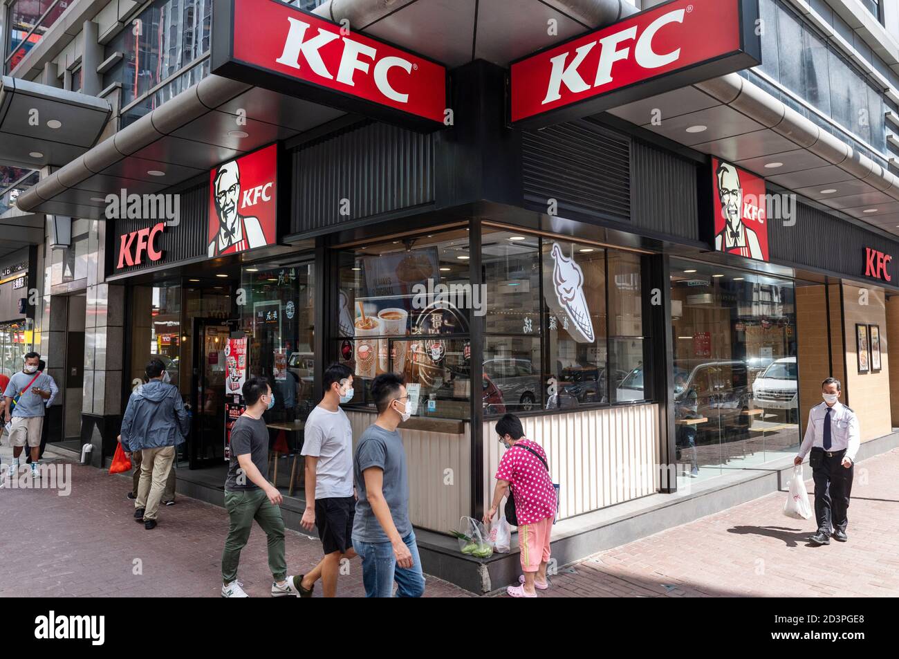 Pedestrians wearing masks are seen in front of the American fast food ...