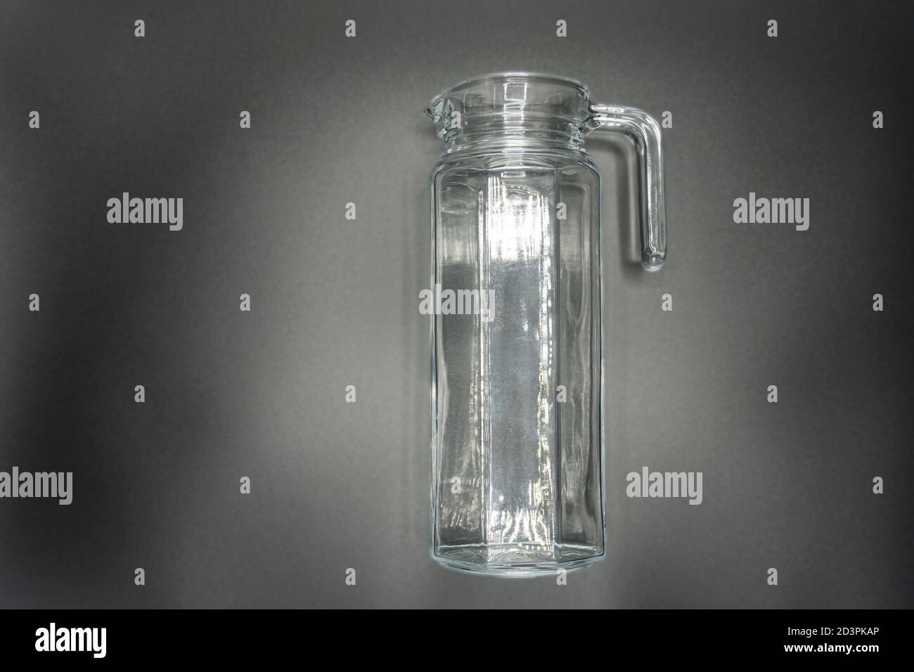Empty pitcher, glass jug for beverages isolated on gray background ...