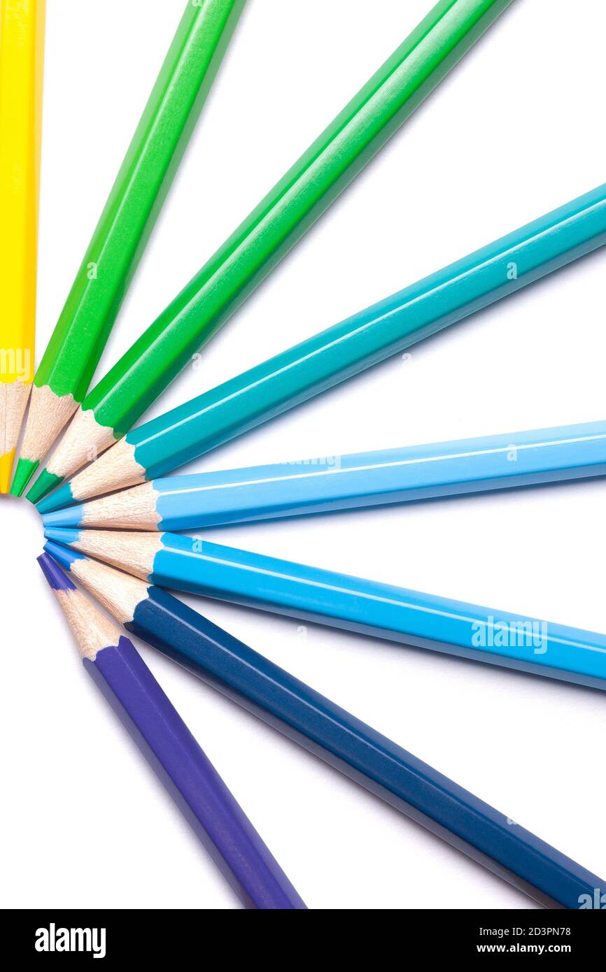 a semicircle of blue and green sharp pencils on a white background ...