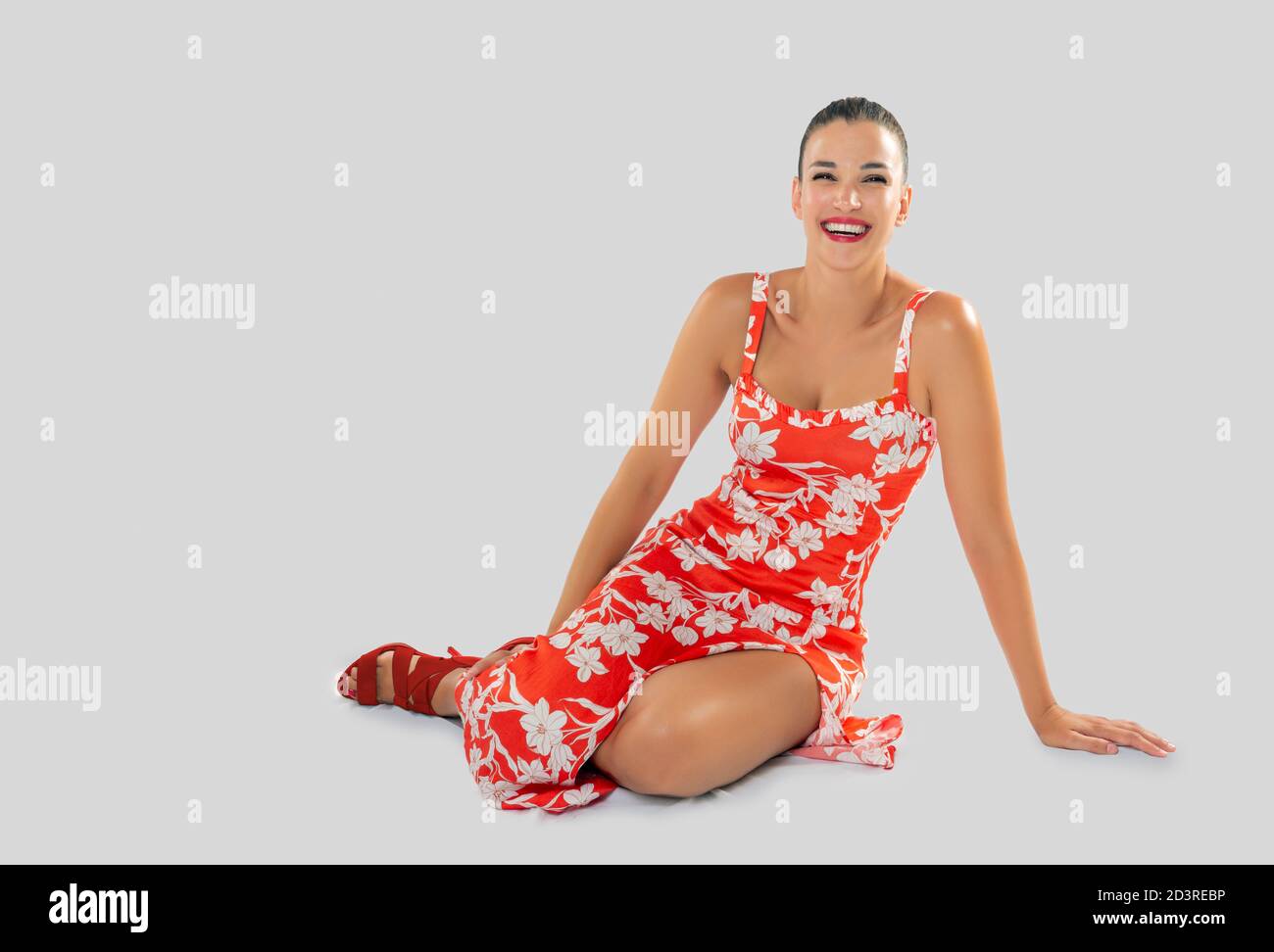 Girl in flowery and cheerful dress of bright colors posing sitting on ...