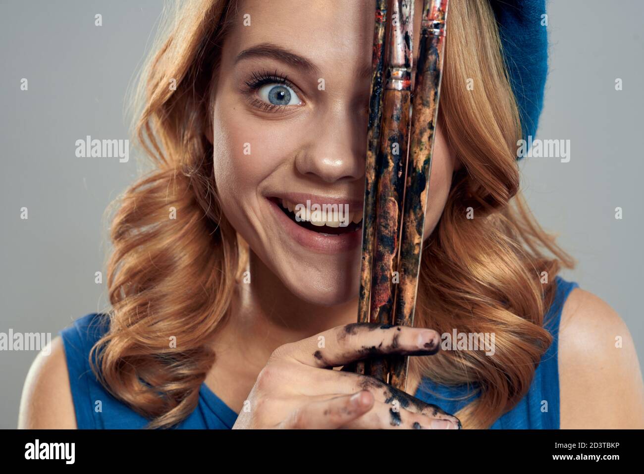 Pretty woman artist paintbrush near face blue beret close-up art Stock ...