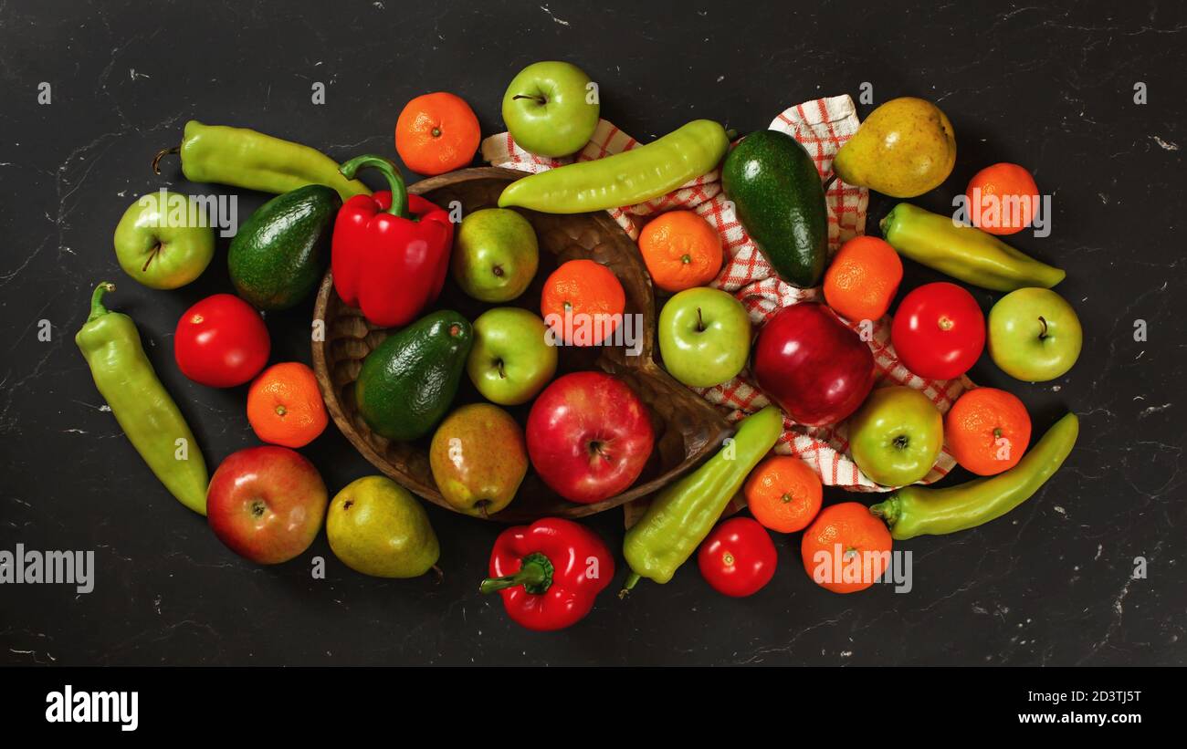 Mixed fruits and vegetables on black marble like board, healthy food ...