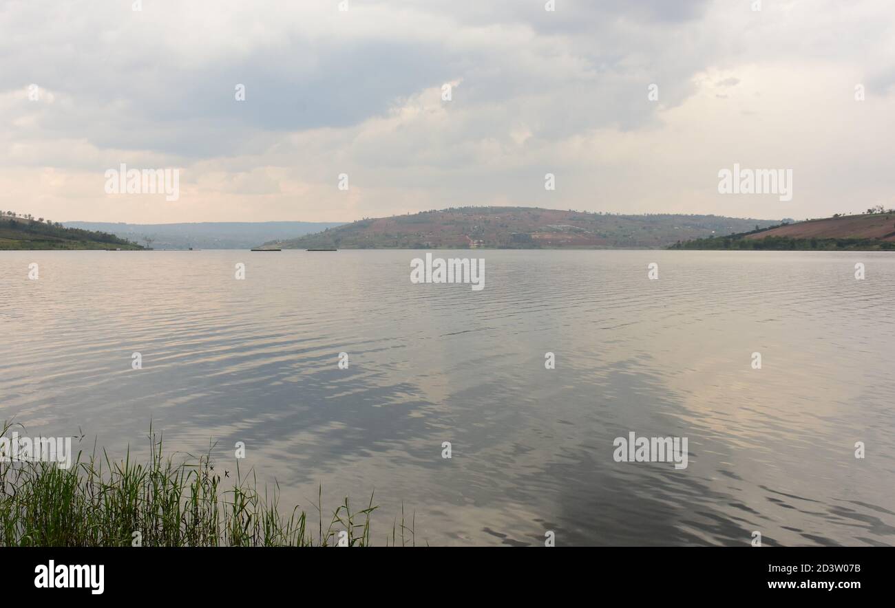 Lake Muhazi water and small hills on the shores and the blue sky with ...