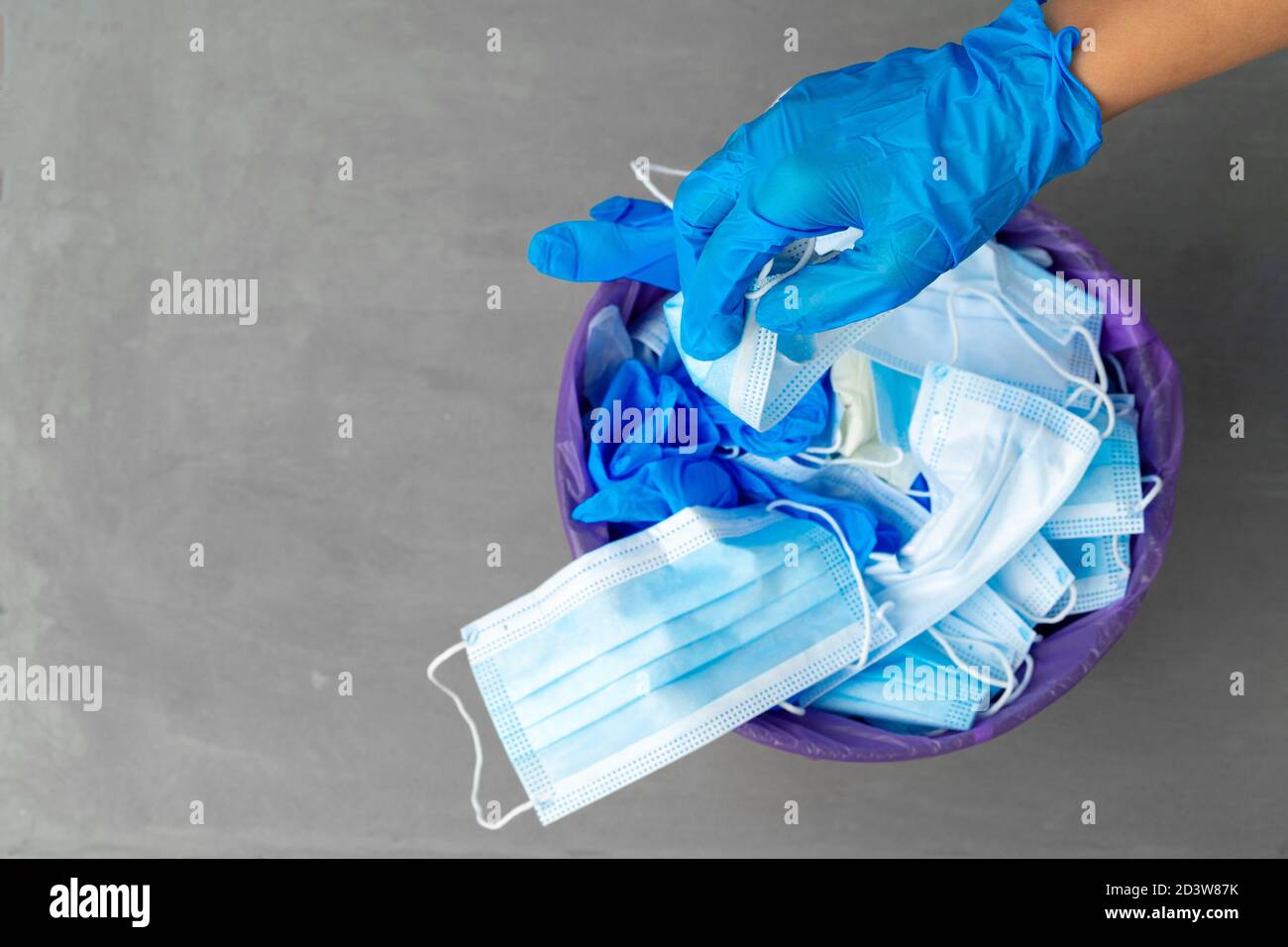 Hand putting used dirty surgical mask to a garbage bin Stock Photo - Alamy