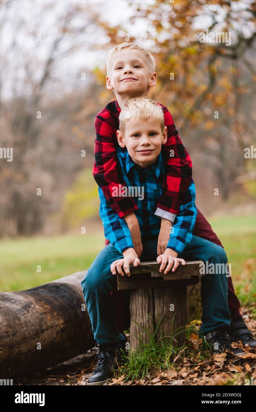 Two charming boys brothers primary school age, 6-7 years old, sit at ...