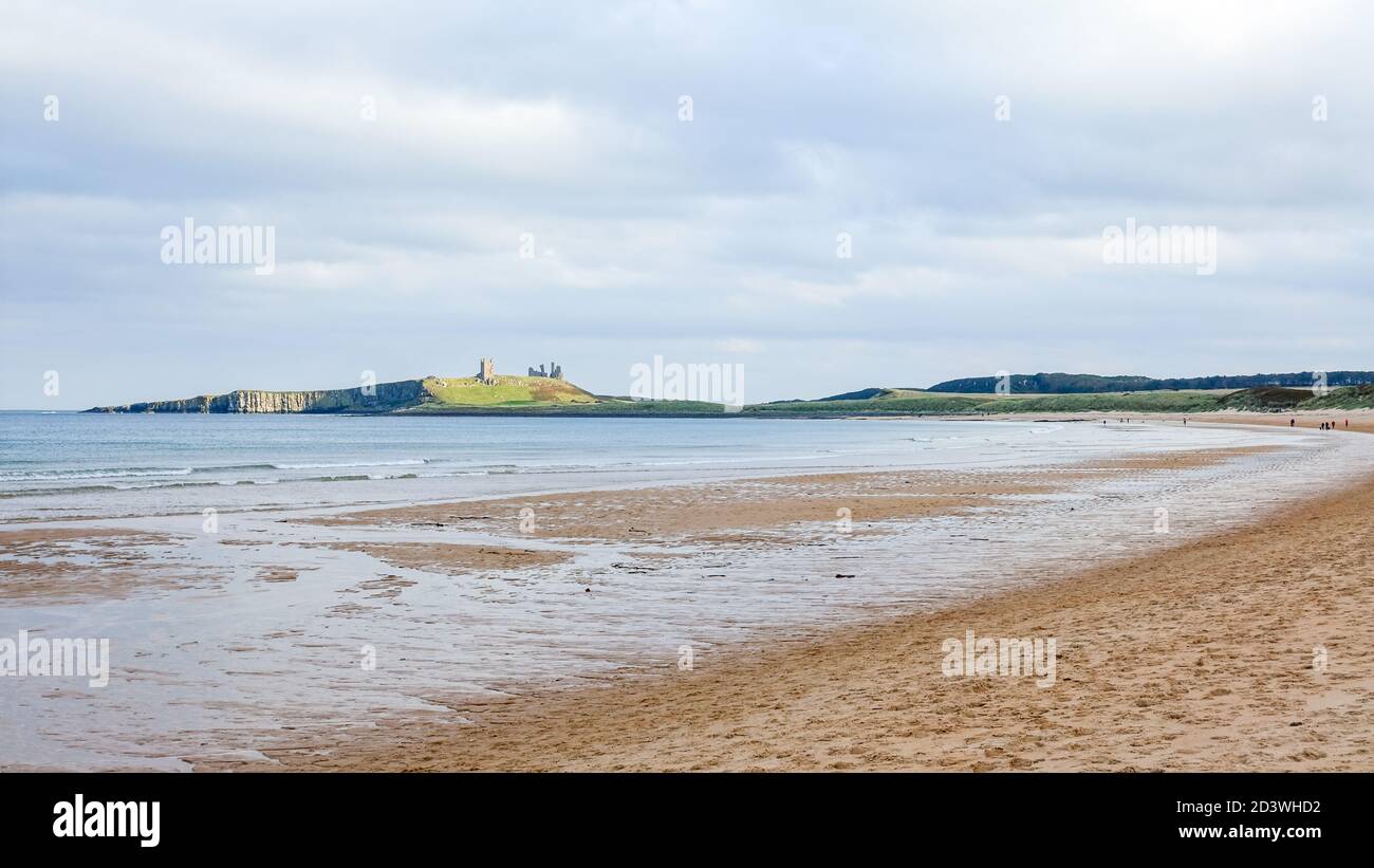 Dunstanburgh Castle across a golden sandy beach Stock Photo - Alamy