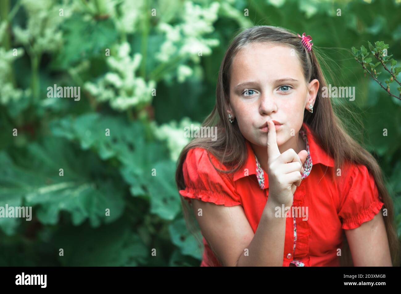 Teen young girl with her finger over her mouth, hushing Stock Photo - Alamy