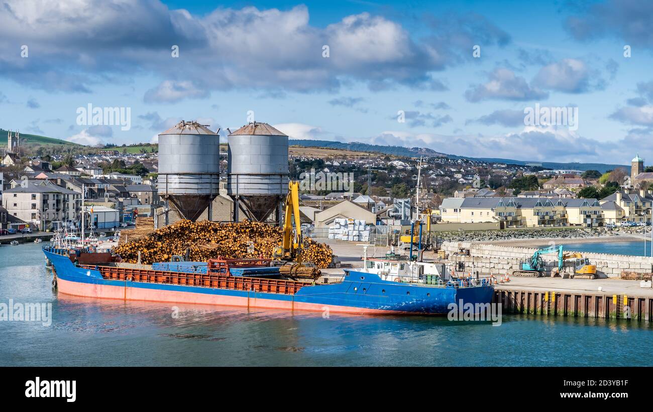 Crane with wood logs gripple loading timber on cargo ship for export in ...