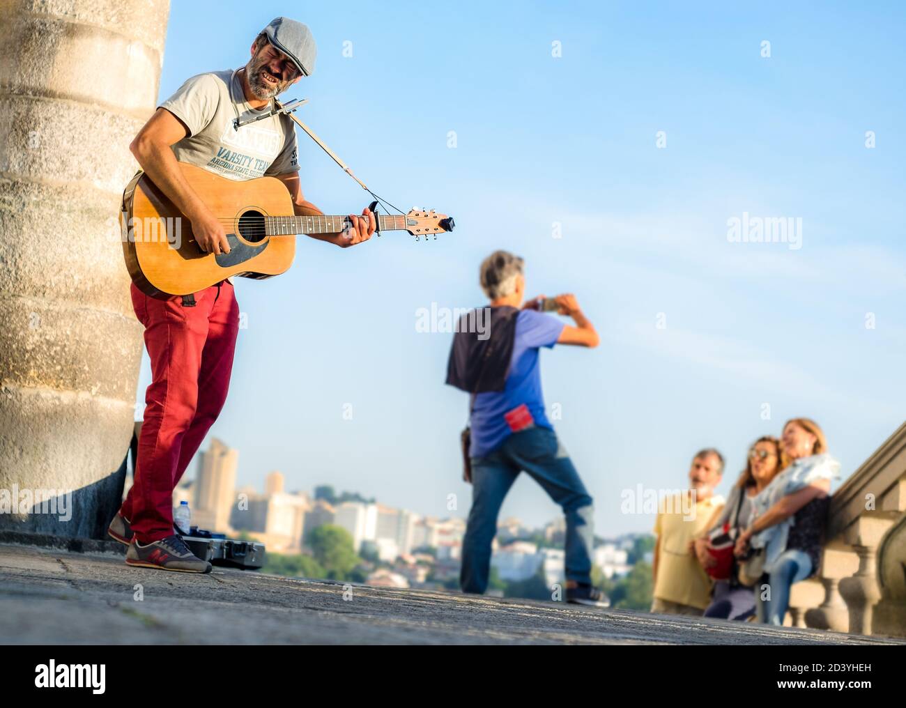 Street singer and guitarist performing live in the street while ...