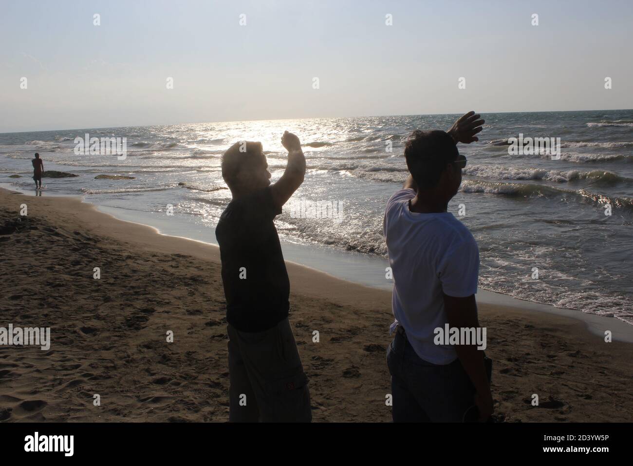 Two men looking at the sunset beach Stock Photo - Alamy