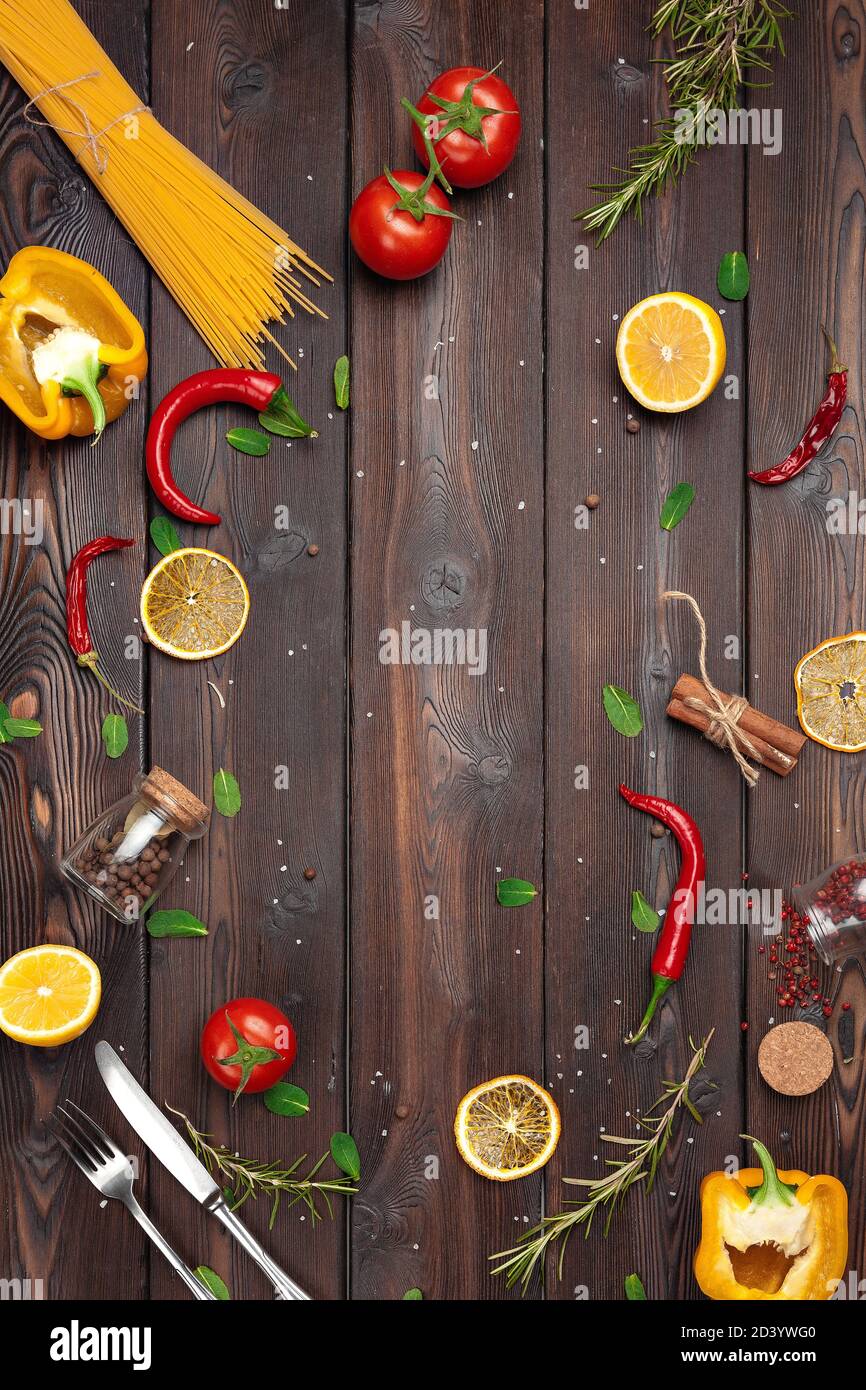 Wooden cooking background with scattered herbs and spices and copy ...