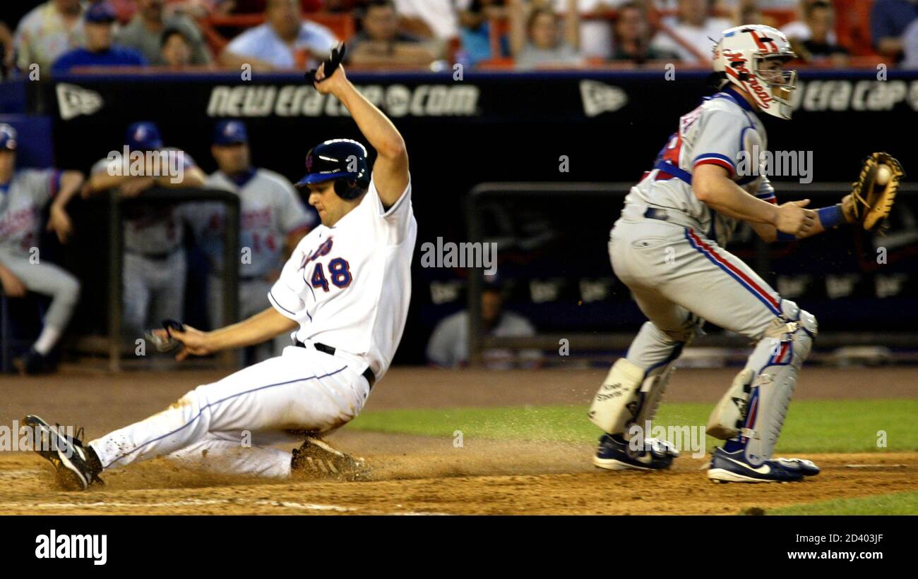 Aaron Heilman of the New York Mets slides home ahead of the throw to ...