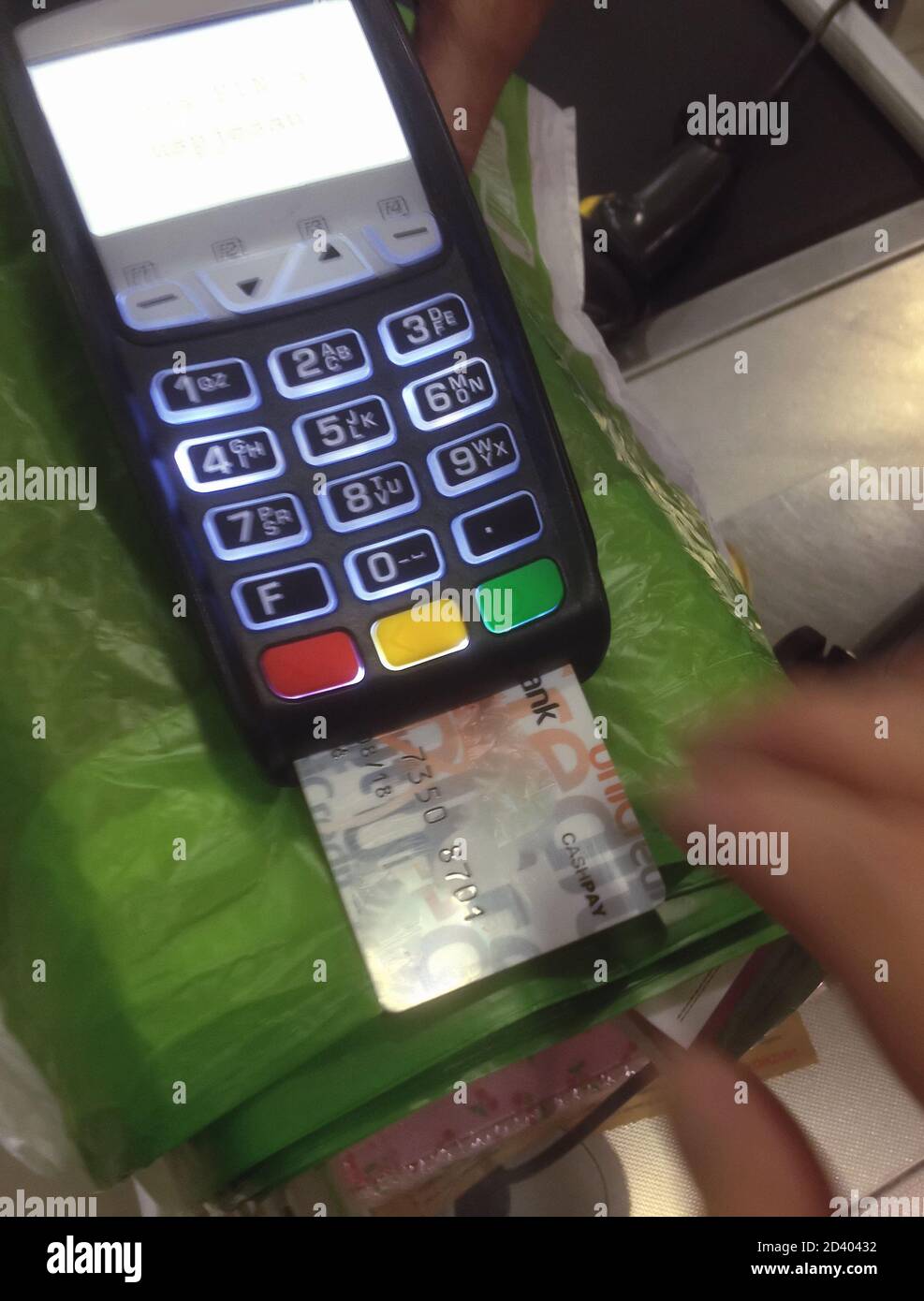 Hand with credit card swipe through terminal for sale in supermarket ...