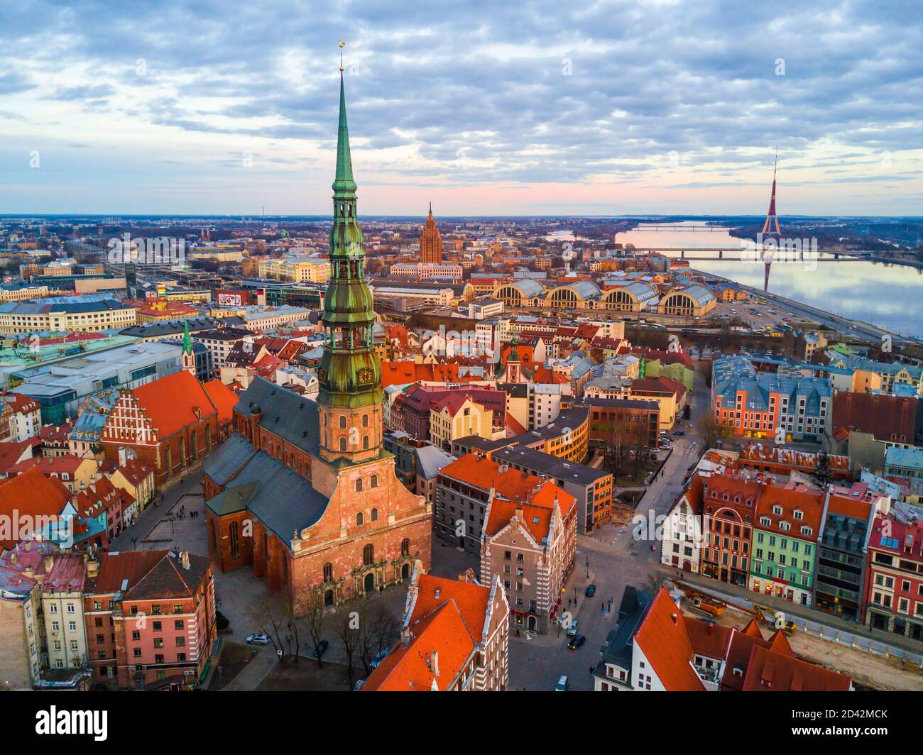 St. Peters cathedral surrounded by buildings under a cloudy sky in Riga ...