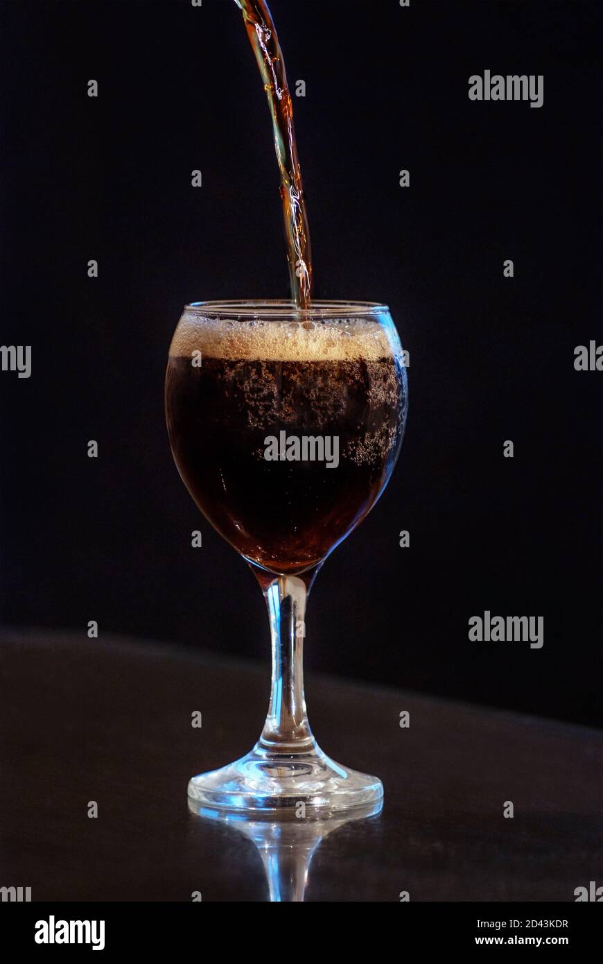 pouring coca cola juice into clean glass isolated on black background ...