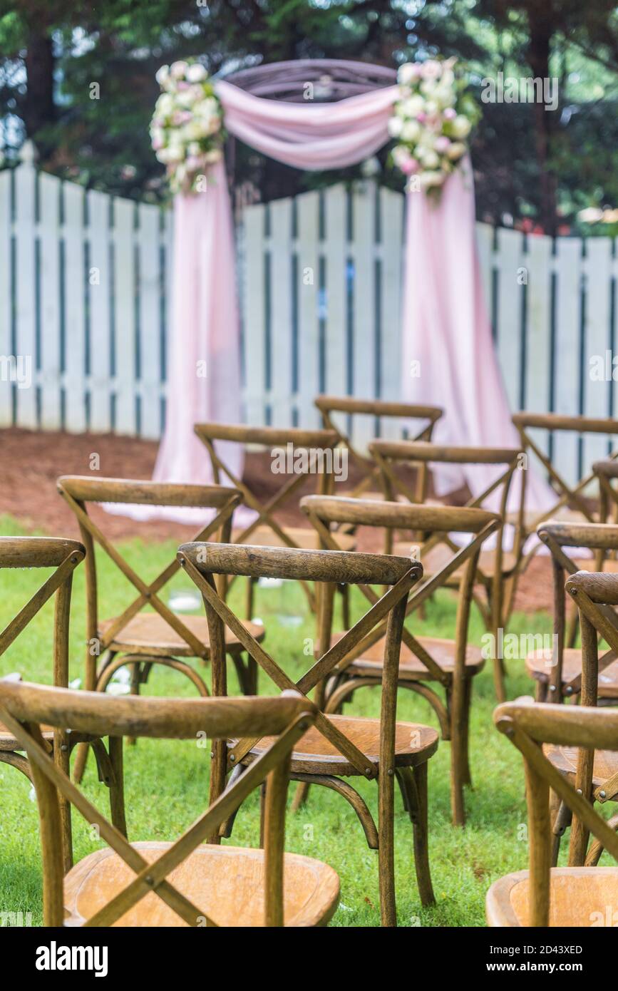 Vertical shot of rows of wooden tables on the outdoor wedding ceremony ...
