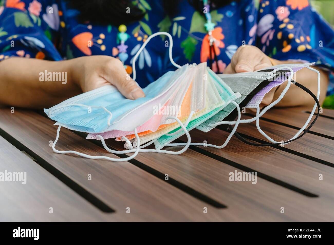 Quarantined woman choose colorful surgical masks to wear to prevent the ...