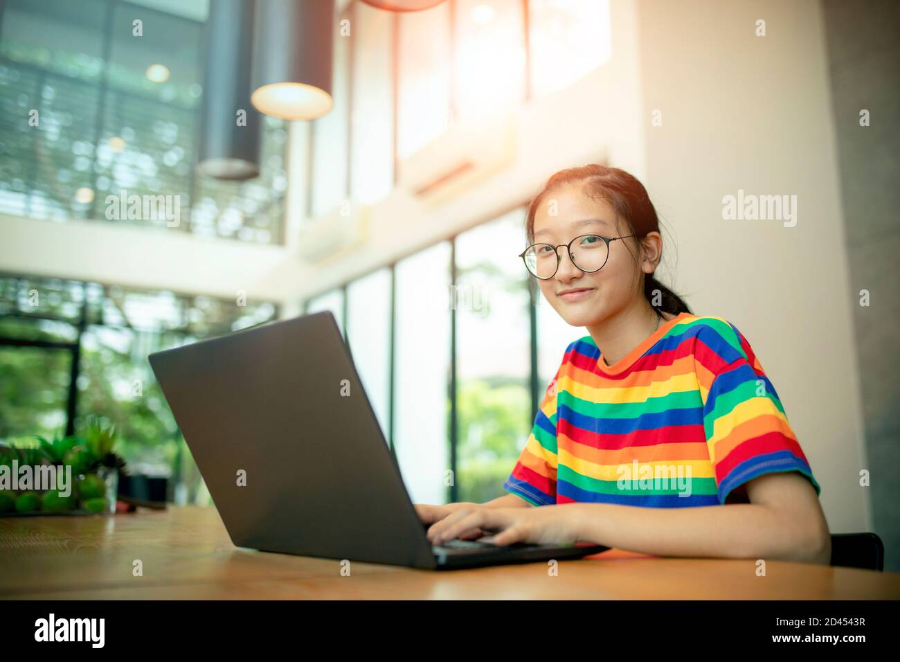 asian teenager working on computer laptop with smiling face Stock Photo ...