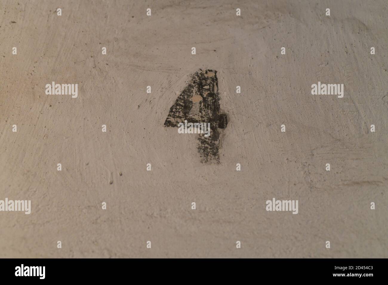 Closeup shot of number 4 marked on the wall in the Nazi concentration ...