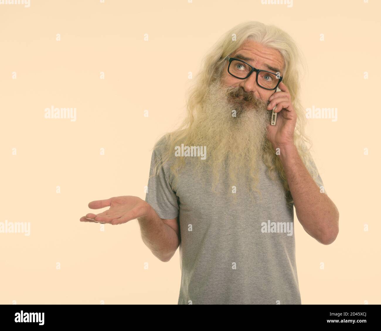 Studio shot of senior bearded man thinking while looking confused and ...