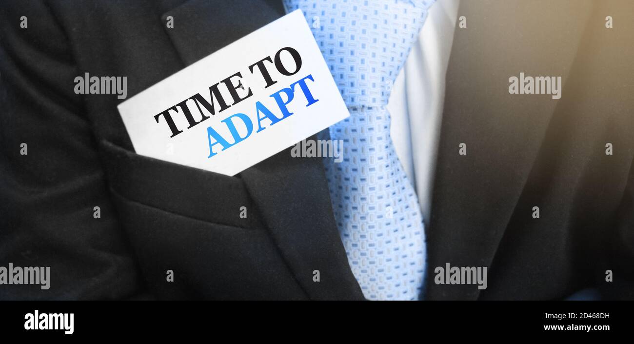 Time to adapt on a card in upper pocket of businessman. Crisis ...