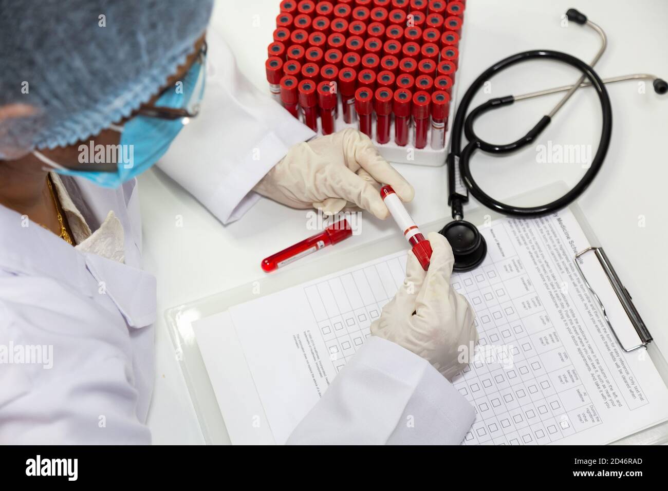Indian doctor examine patient blood test sample vials while preparing ...