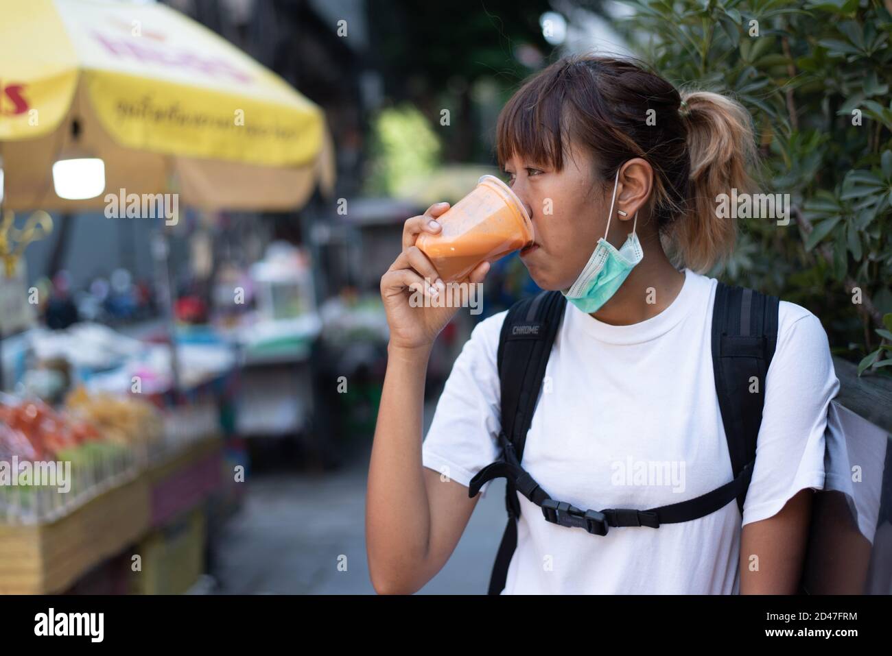 Asian woman with surgical face mask feel tired have a drink some ...