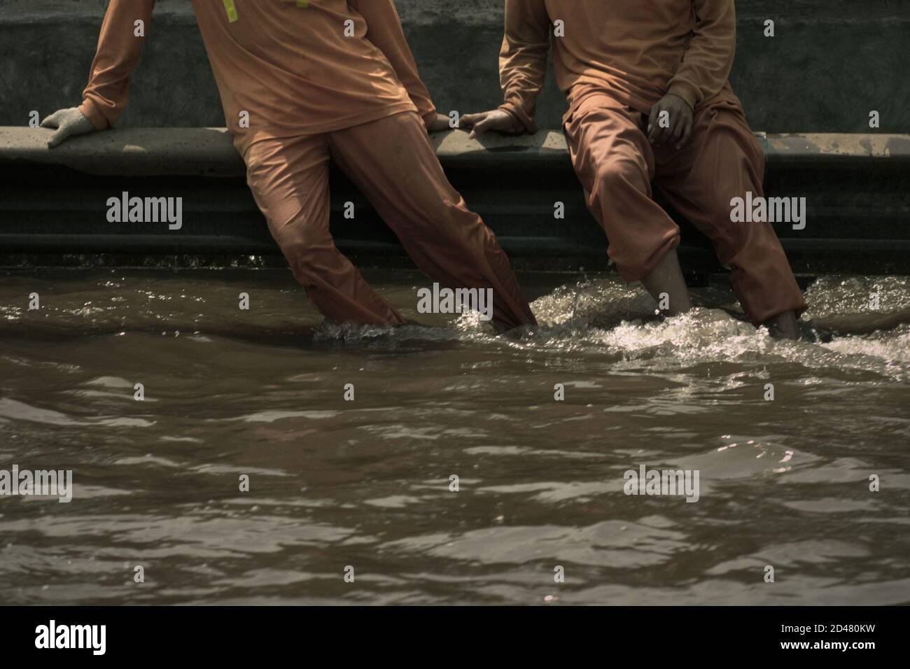 Workers taking a pause from flood mitigation work, sitting on a metal ...