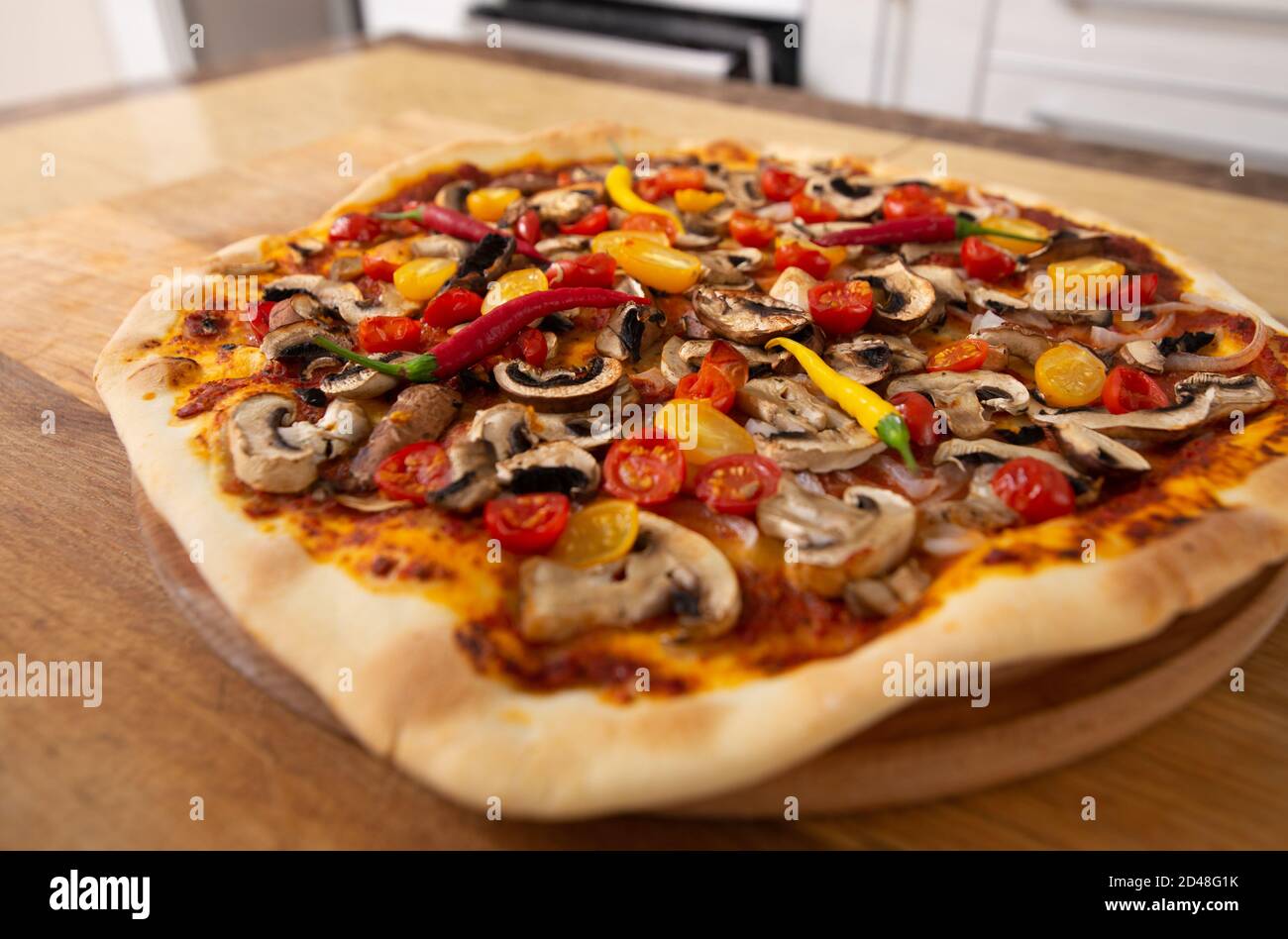 Top view of finished pizza just taken out of the oven. Next is a plate ...