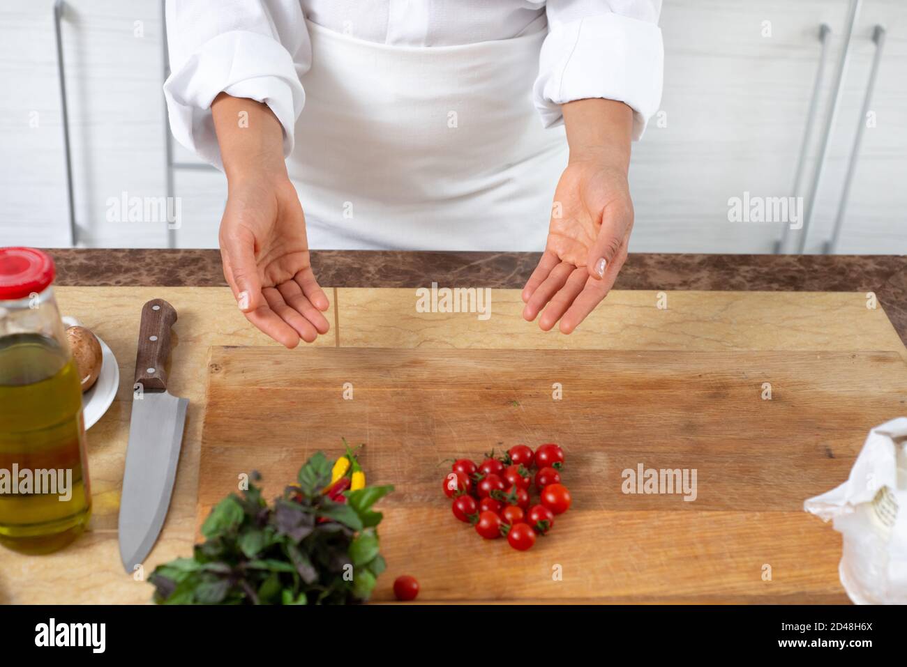 A cook shows with his hands at the table with ingredients Stock Photo ...