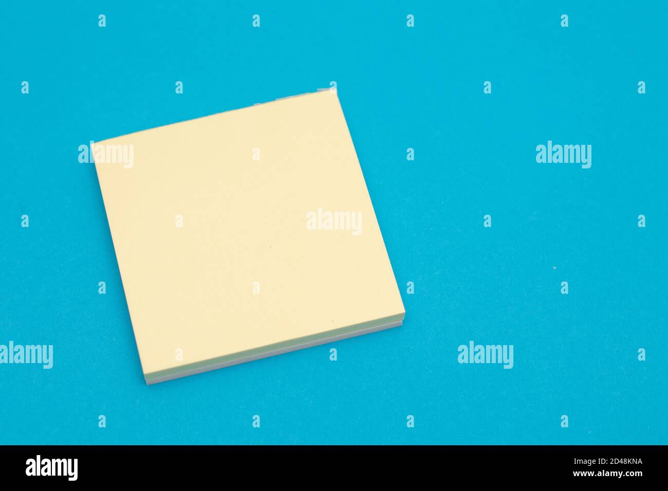 Stack of yellow paper stickers on blue background Stock Photo - Alamy
