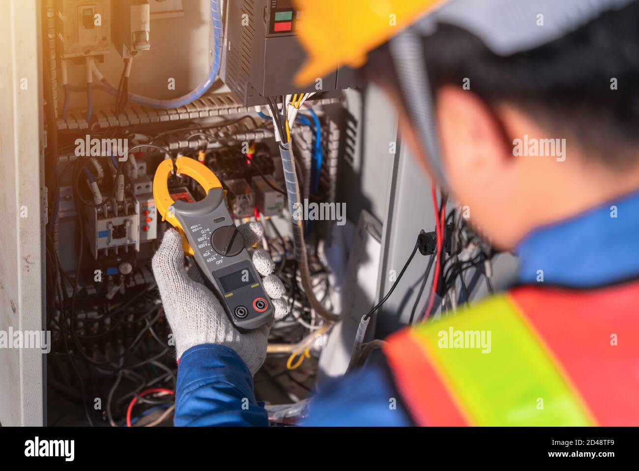 Digital clamp meter in hands of electrician close-up against background ...