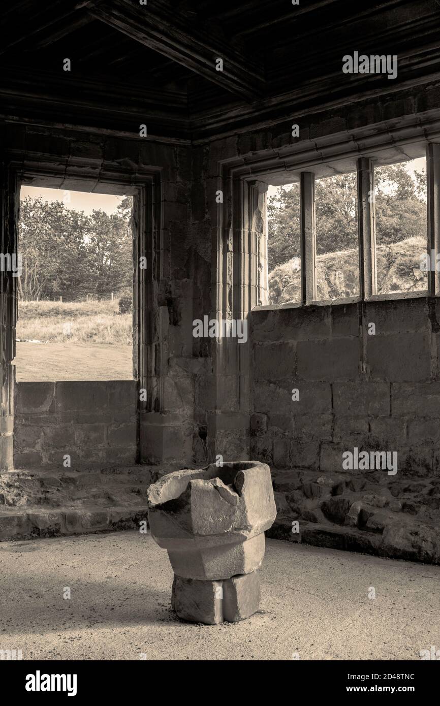 Chapter house interior of a medieval abbey, with a stone font. With ...