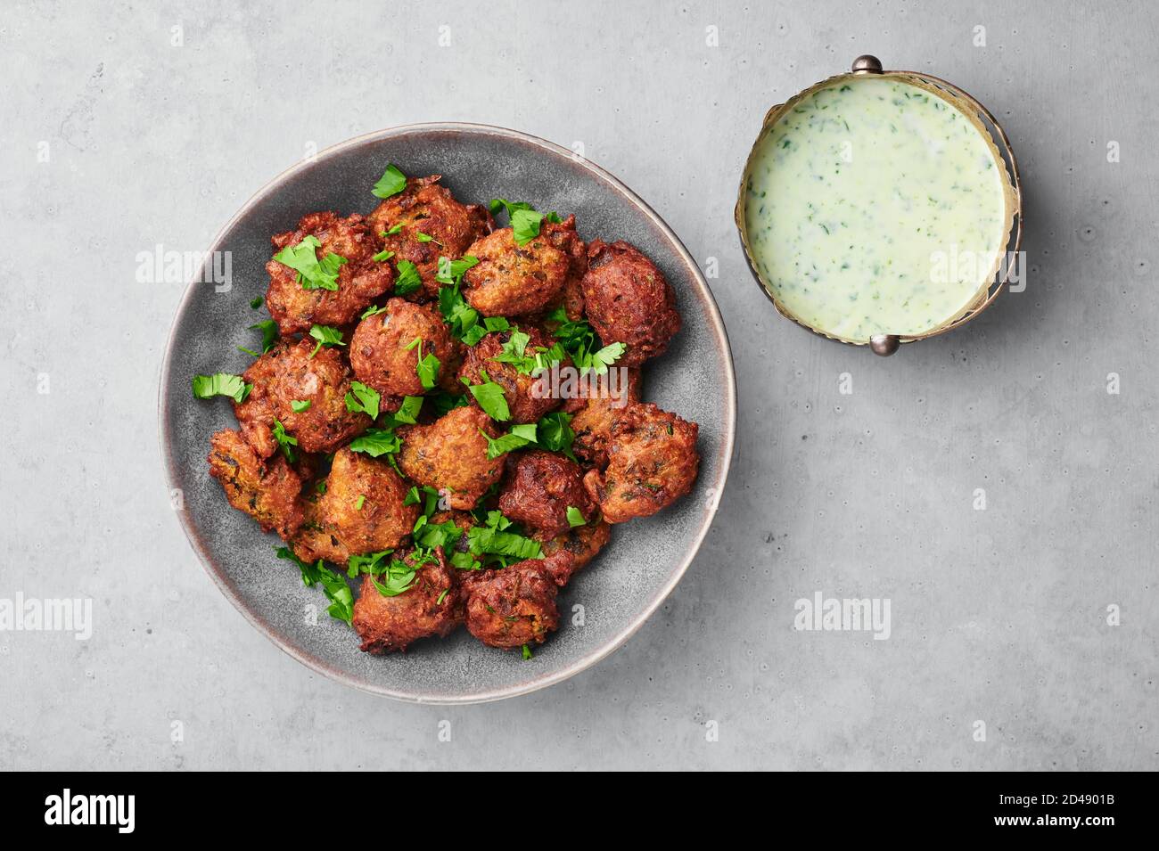 Veg Pakora in gray bowl on concrete table top. Pakoda is indian cuisine ...
