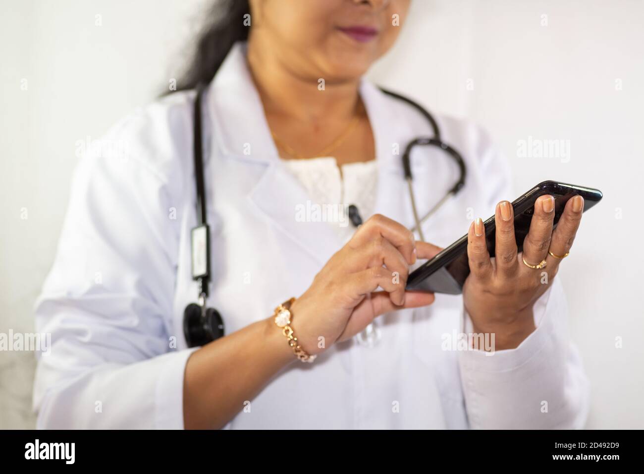 Indian doctor checks on her mobile phone at a medical clinic at Kolkata ...
