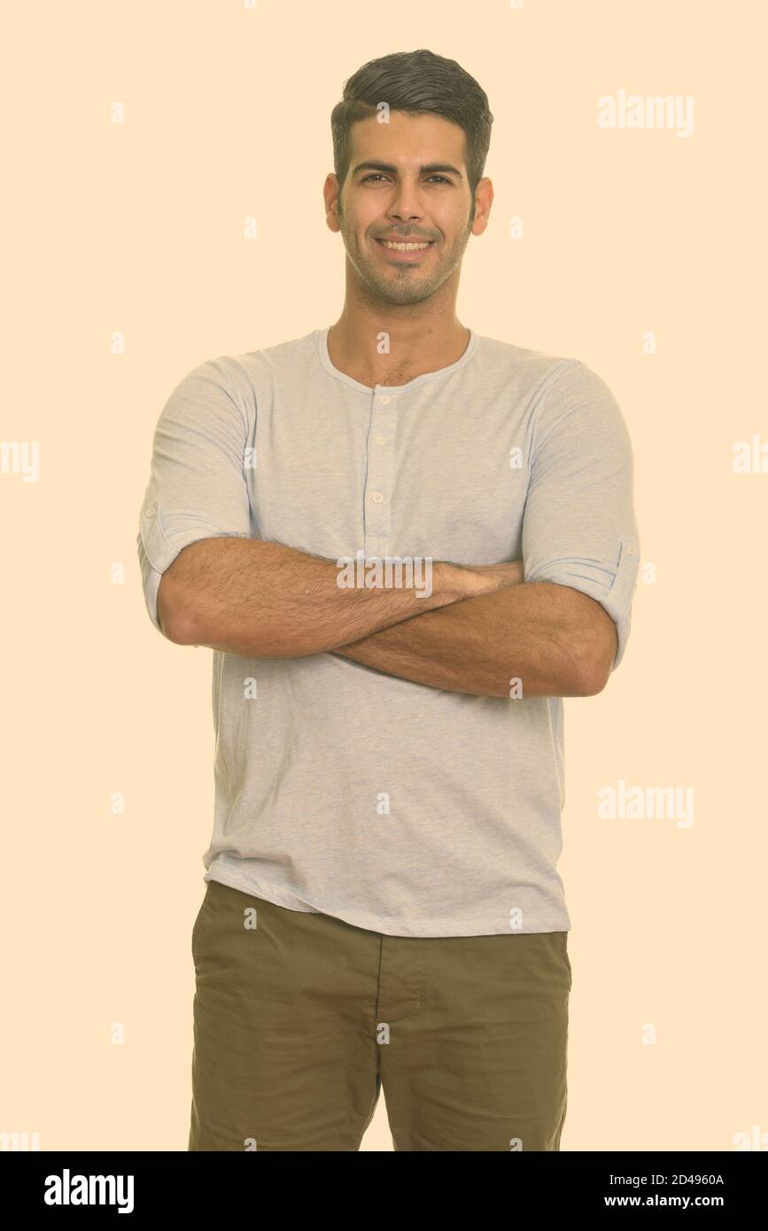 Young happy Persian man smiling with arms crossed Stock Photo - Alamy