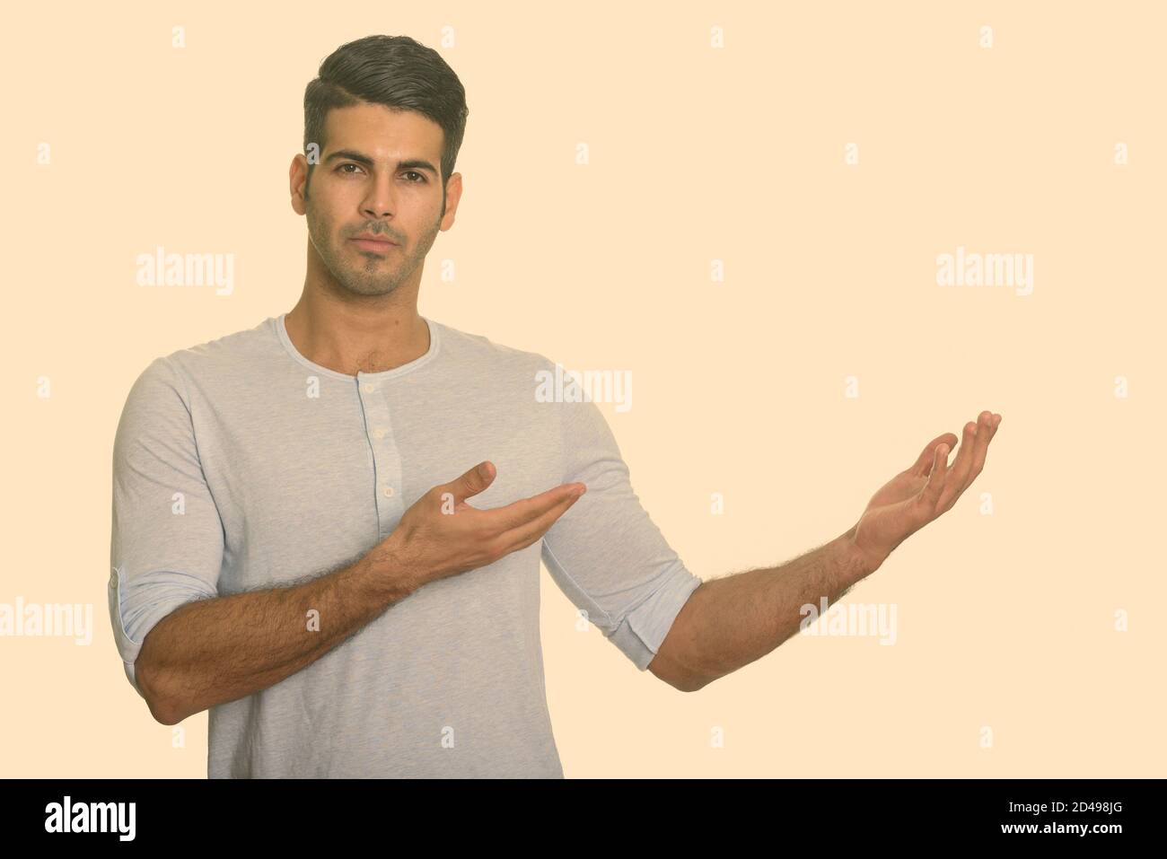 Portrait of young handsome Persian man showing something Stock Photo ...