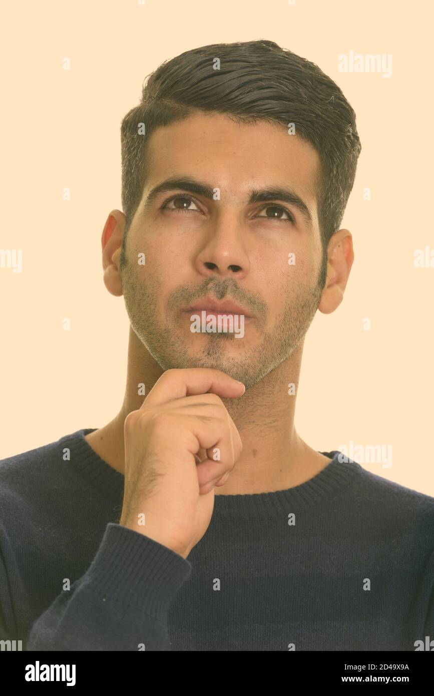 Face of young handsome Persian man thinking Stock Photo - Alamy