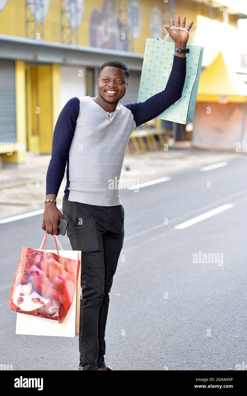 happy man standing in town and carrying shopping bags outdoors Stock ...