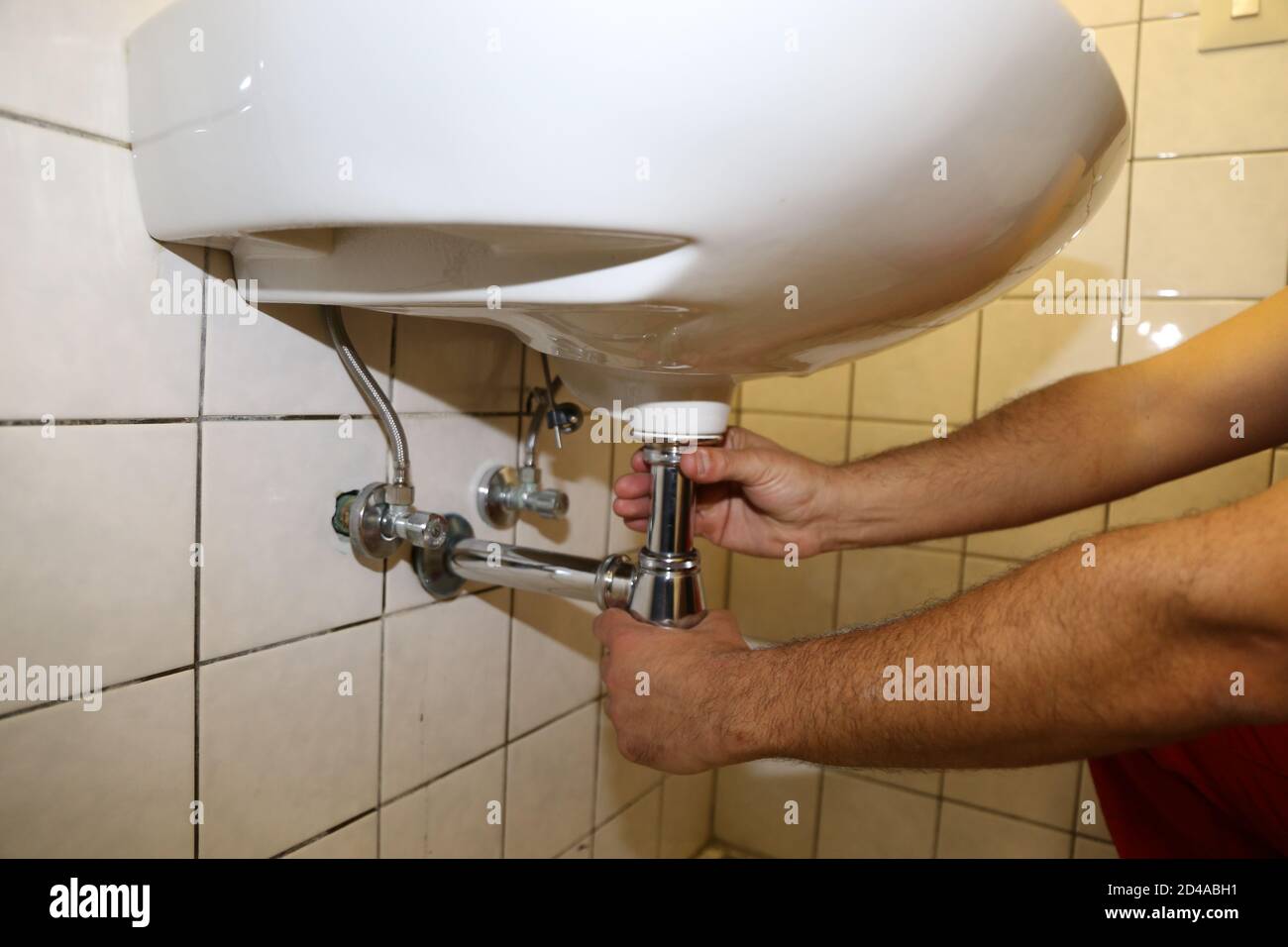 Plumber installs the syphon on a sink Stock Photo - Alamy