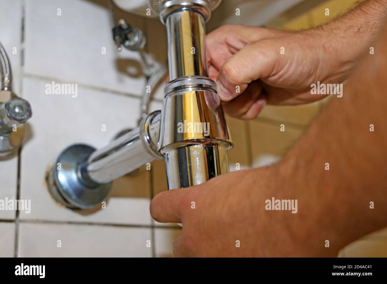 Plumber installs the syphon on a sink Stock Photo - Alamy