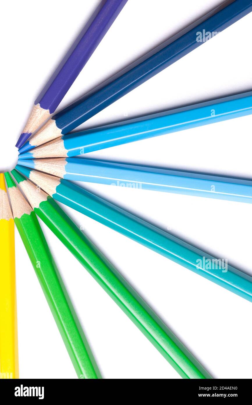 a semicircle of blue and green sharp pencils on a white background ...
