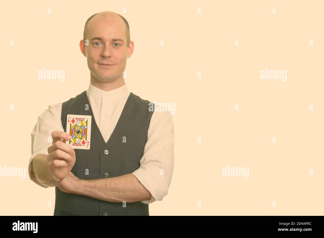 Bald Caucasian magician man holding Jack of Diamonds card with focus on ...