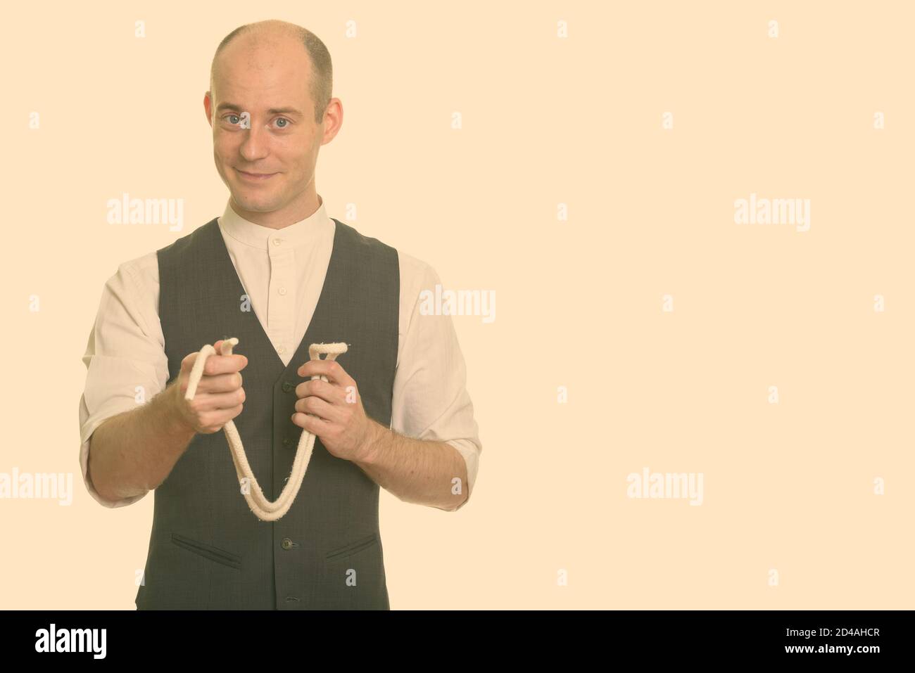 Bald Caucasian magician man holding rope for magic trick Stock Photo ...
