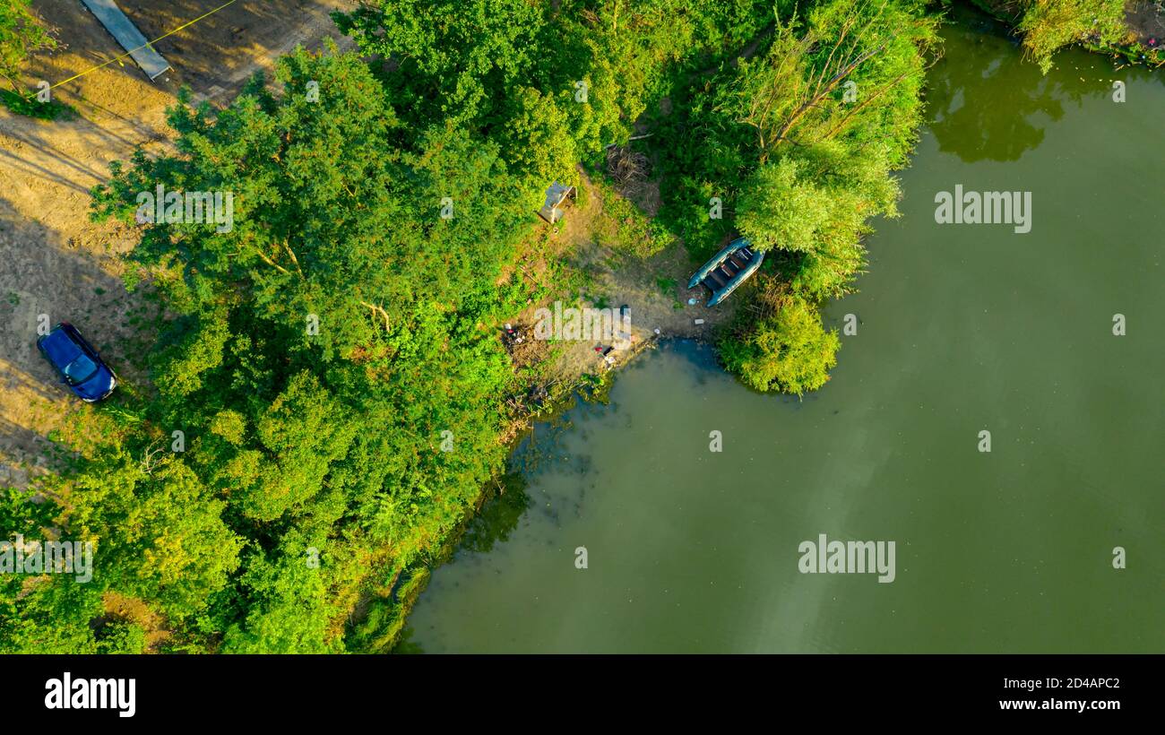 Fishing place on shore of lake, river, in green landscape, dinghy boat ...