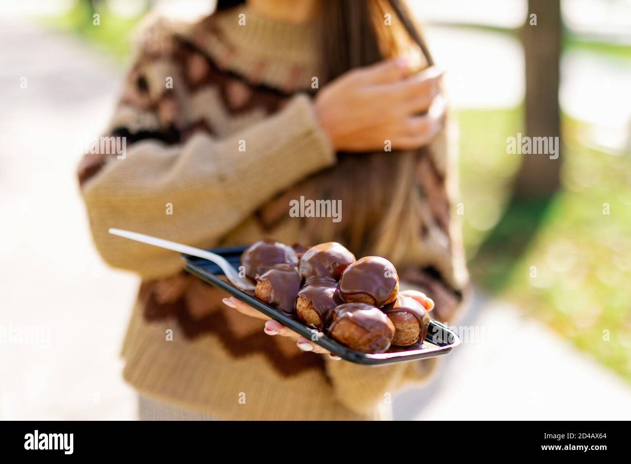 Smiling caucasian female model eating fancy slice cake in outdoor on ...