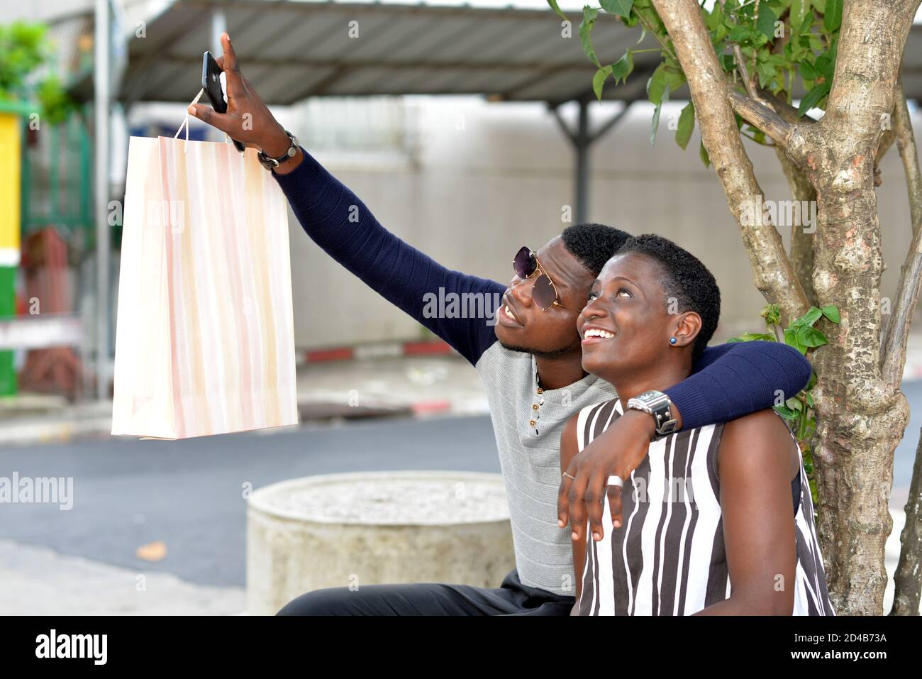 young man sitting showing something to his friend smiling Stock Photo ...