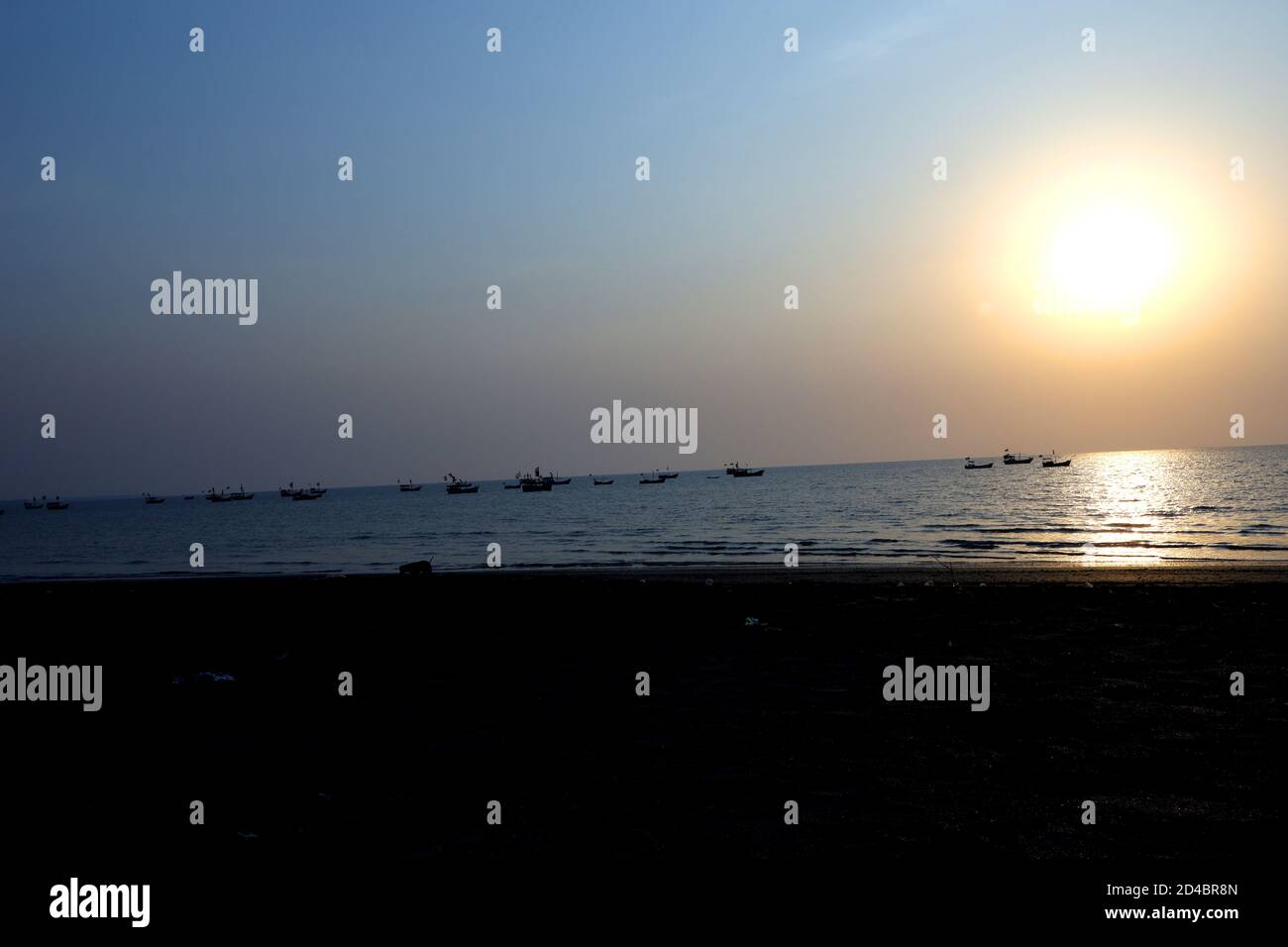 The sunset at a lovely beach crowded by peoples Stock Photo - Alamy